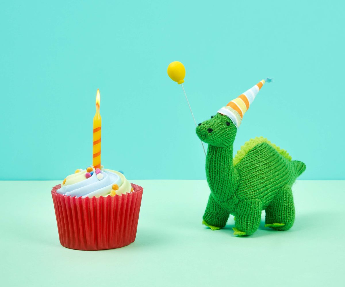 Knitted diplodocus dinosaur with party hat, Spring hanging decoration